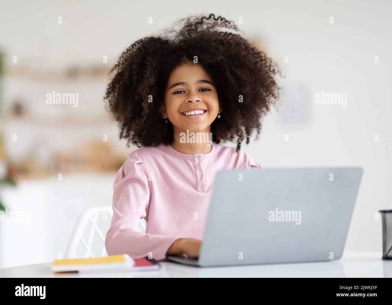 Cute african american school girl typing on laptop keyboard Stock Photo ...