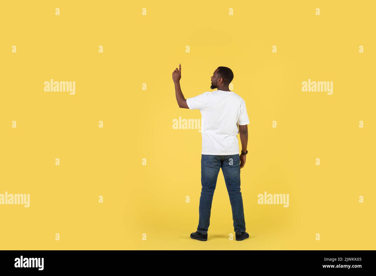 African American Man Pointing Finger Pushing Invisible Button, Yellow ...