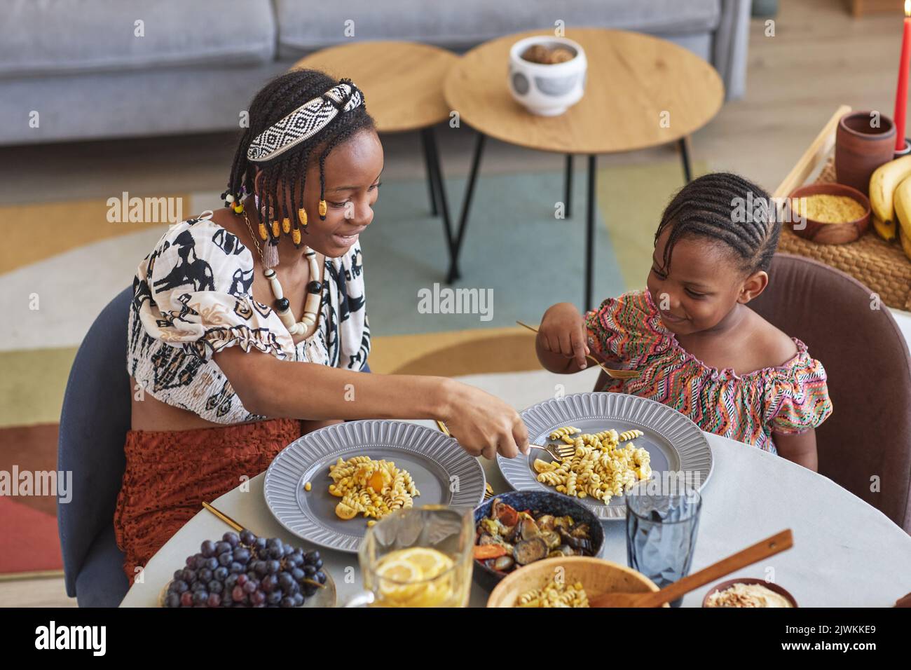 Two African girls in national costumes eating traditional food at ...