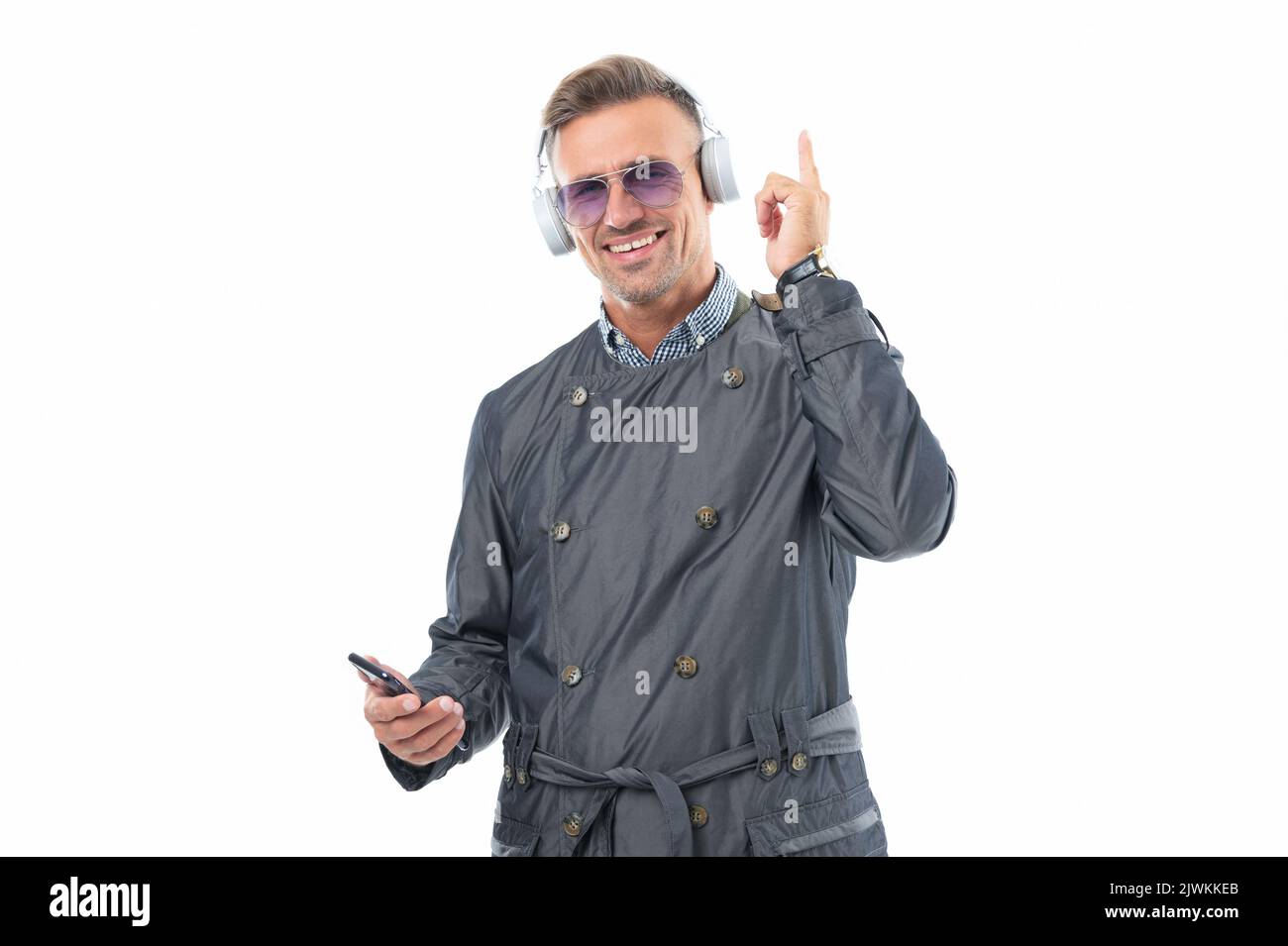 Happy man listening to music pointing finger up. Music player in ...