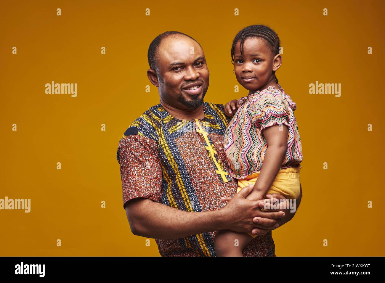 Portrait of African dad holding his little daughter and smiling at ...