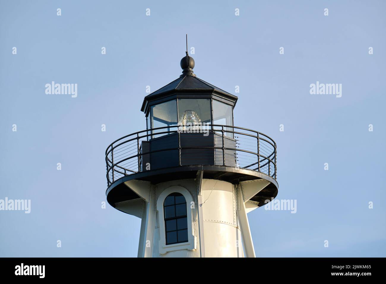 White tall lighthouse on sea shore against blue sky for commercial ...