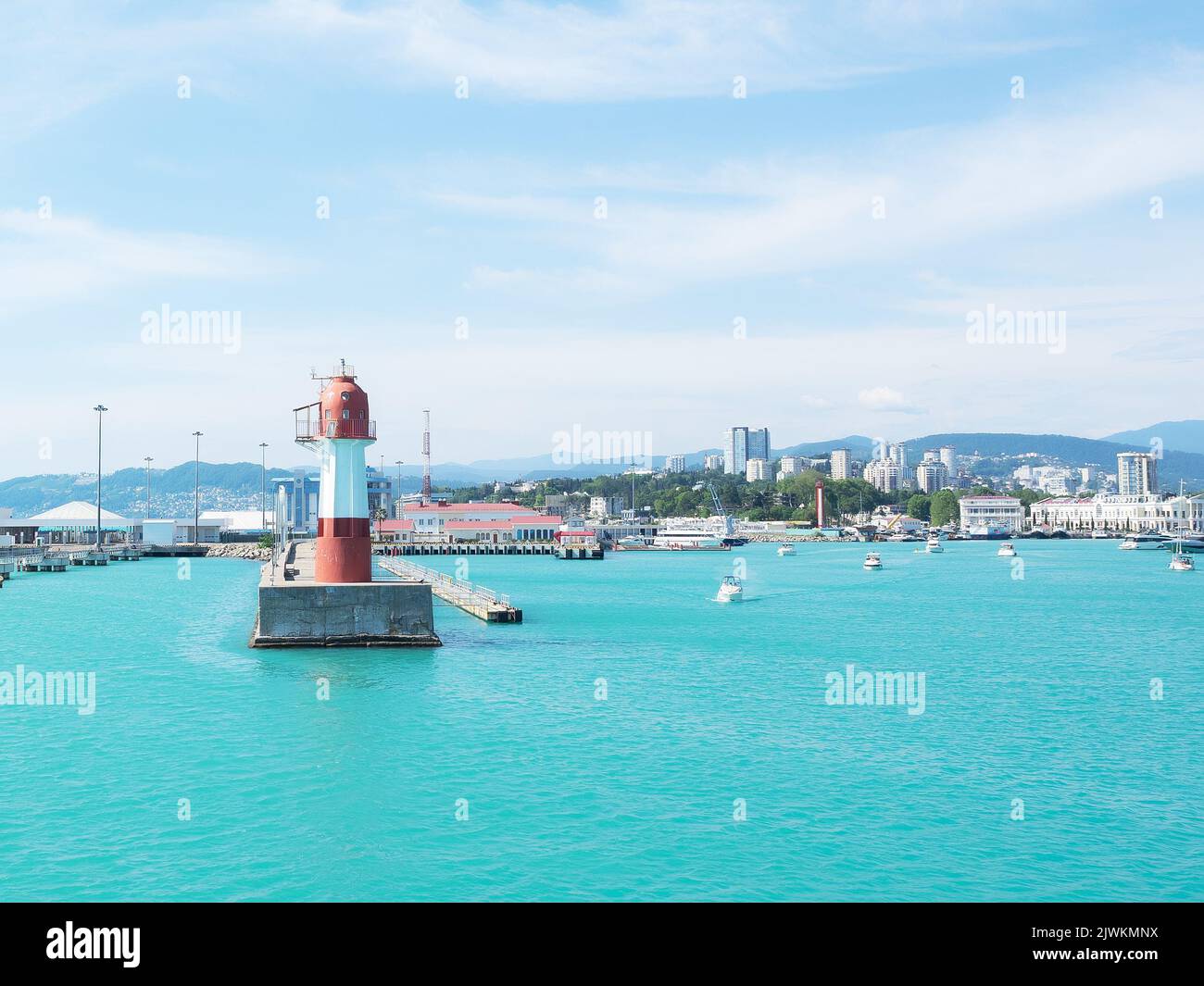 Marine lighthouse in clear weather. Turquoise sea. Pleasure boats Stock ...