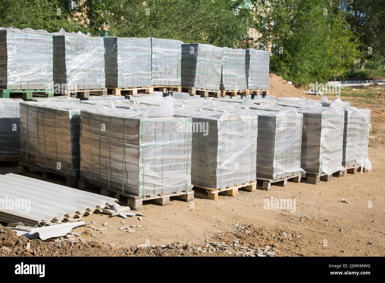 Building materials in packaging lie on wooden pallets in a row at the ...