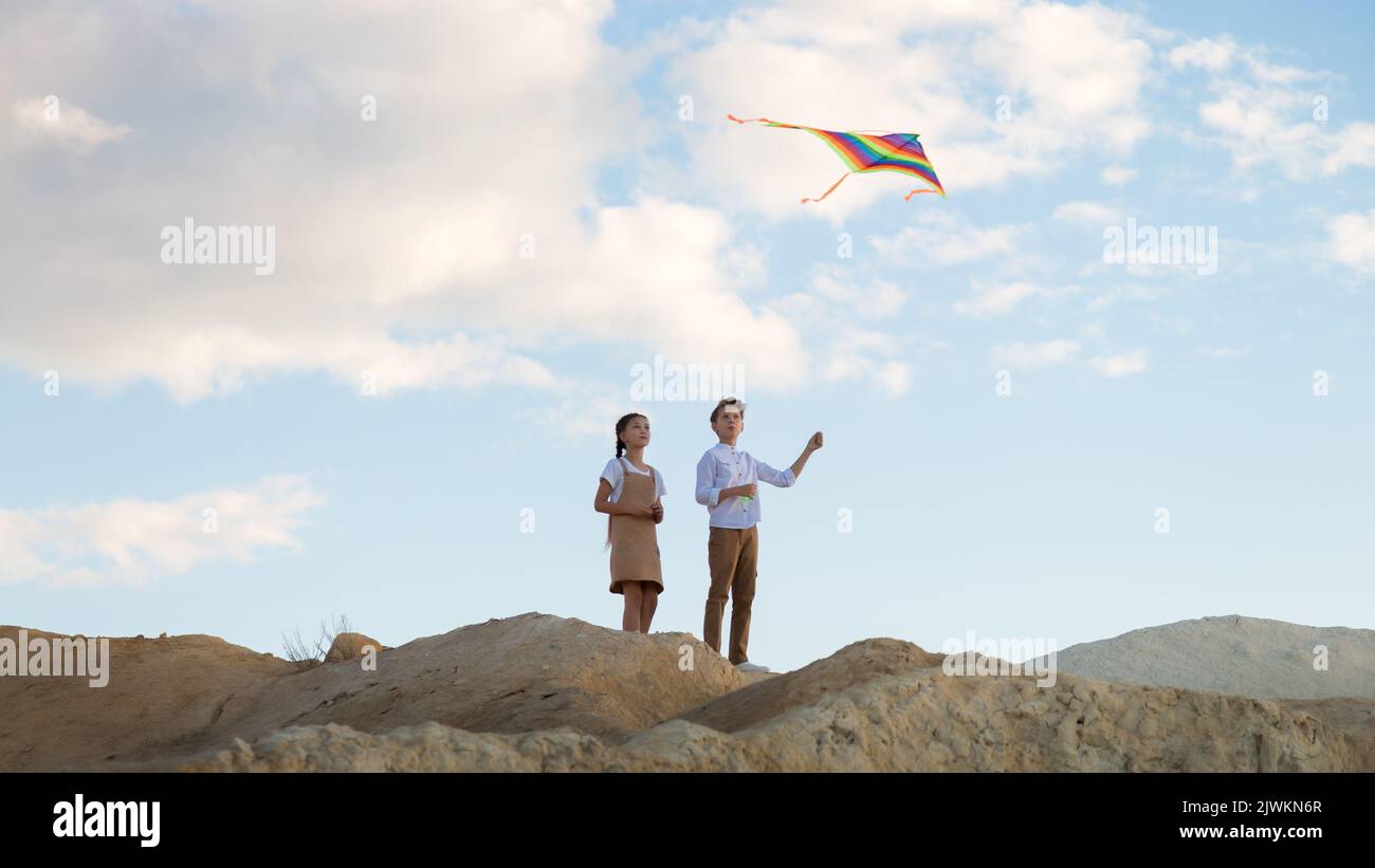 Brother and sister fly a kite into the sky on a high mountain Stock ...