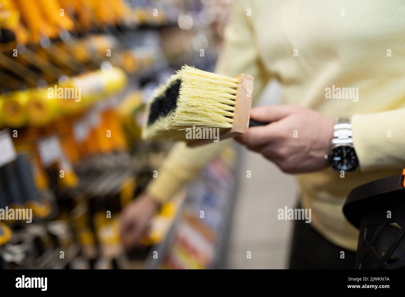 a man in a hardware store holding a paintbrush close-up Stock Photo - Alamy