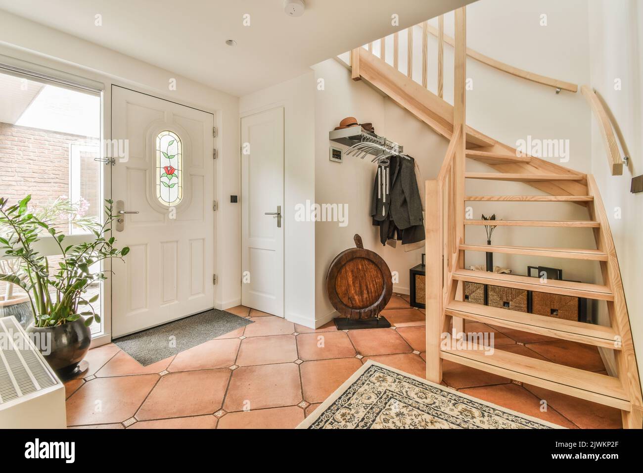 Light hallway with entrance door in two level apartment with minimalist ...