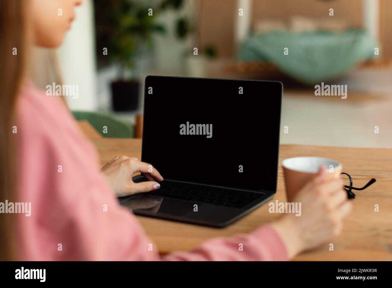 Schoolgirl using laptop with blank screen, learning and doing homework ...