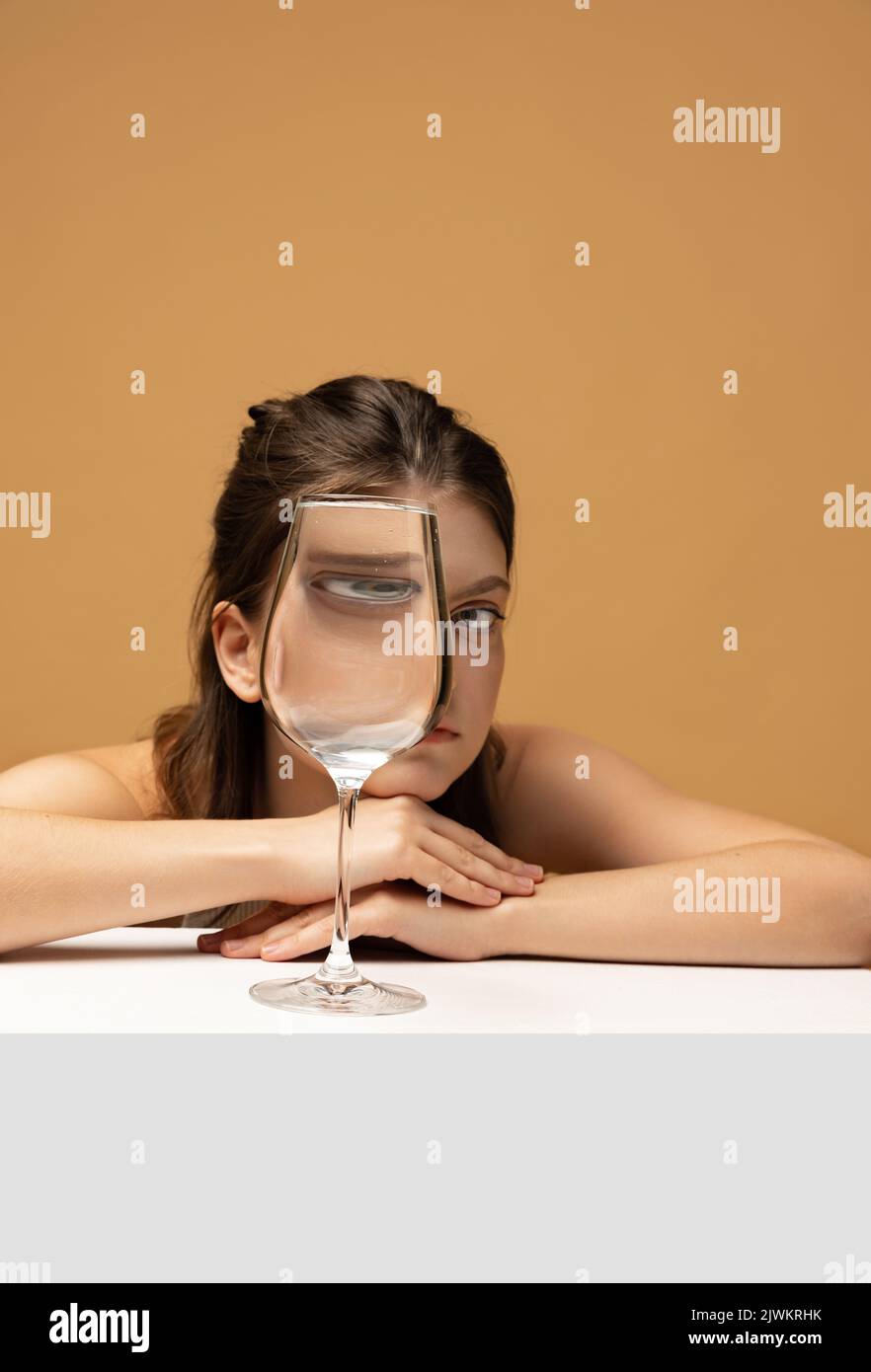 Modern art photography. Beautiful girl's face through wine glass ...