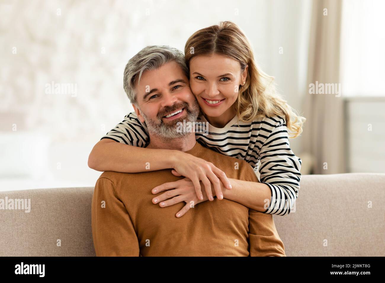 Happy Middle Aged Wife Hugging Husband At Home Stock Photo - Alamy