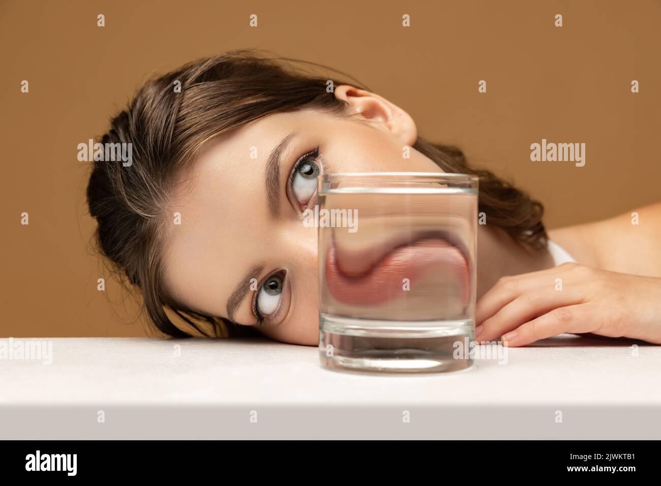 Modern art photography. Beautiful girl's face through glass of water ...
