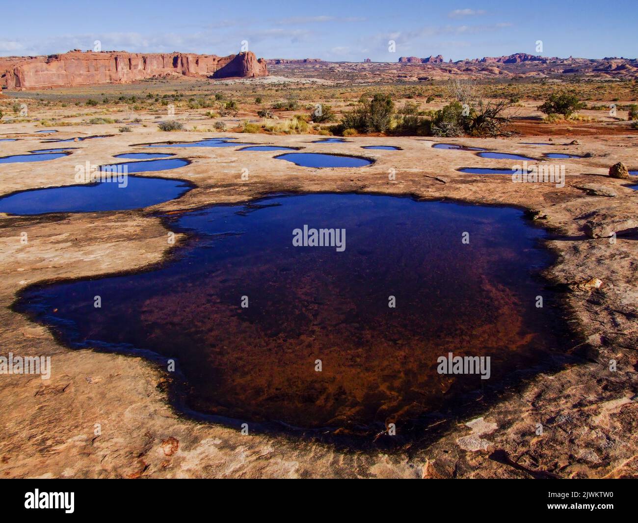 Ephemeral rainwater pools in potholes in Navajo sandstone in Arches ...