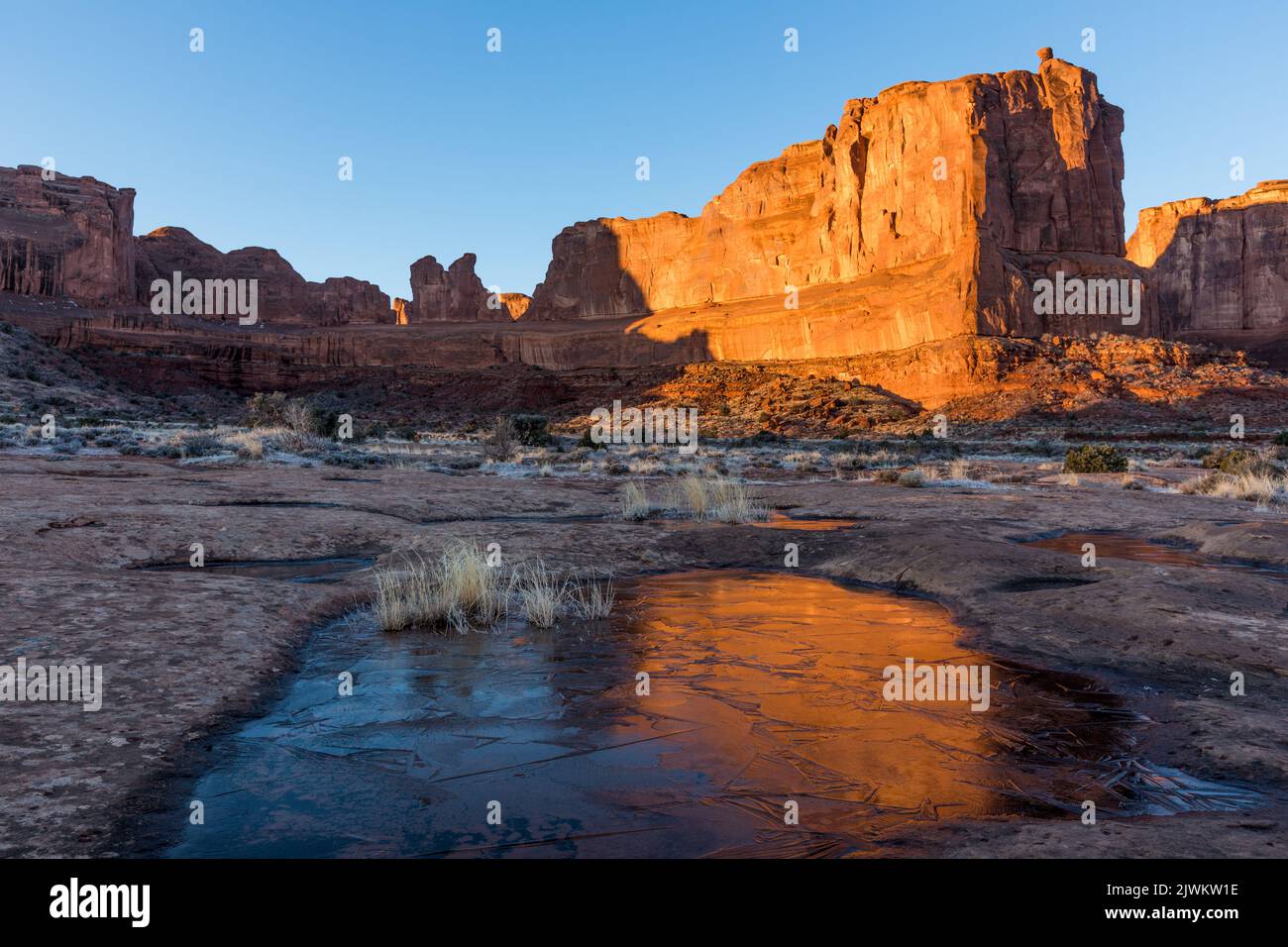 Red sandstone reflected in any icy pothole filled with snowmelt in the ...