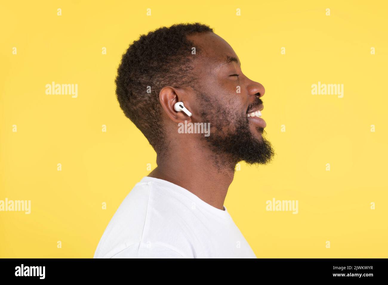 Happy African Man Listening Music Wearing Earbuds Over Yellow Background Stock Photo - Alamy