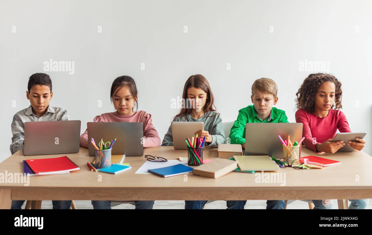 Five Multiethnic School Kids Using Laptops In Classroom, Panorama Stock Photo - Alamy