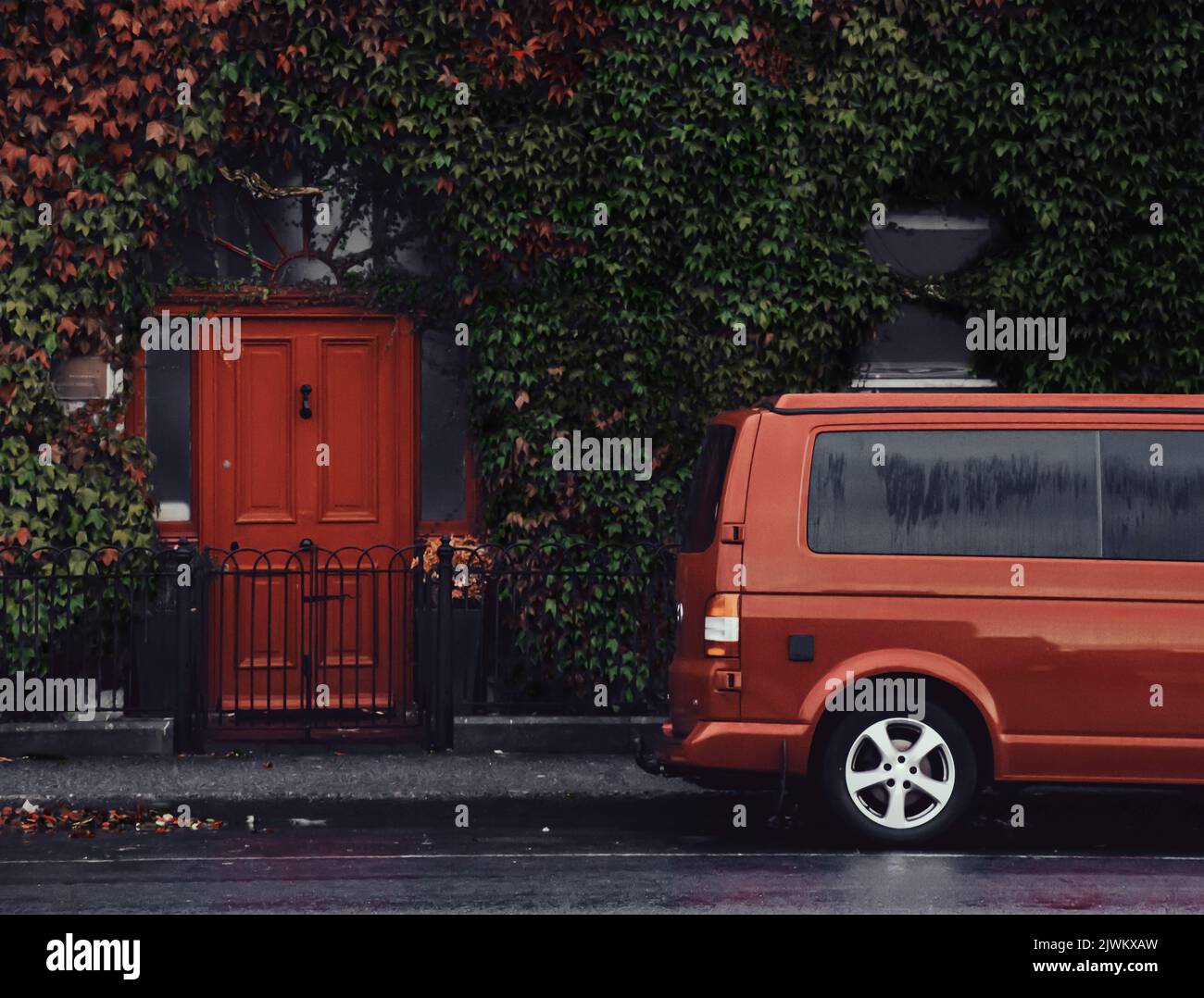 Red minivan parks in front of a house with a red door Stock Photo - Alamy