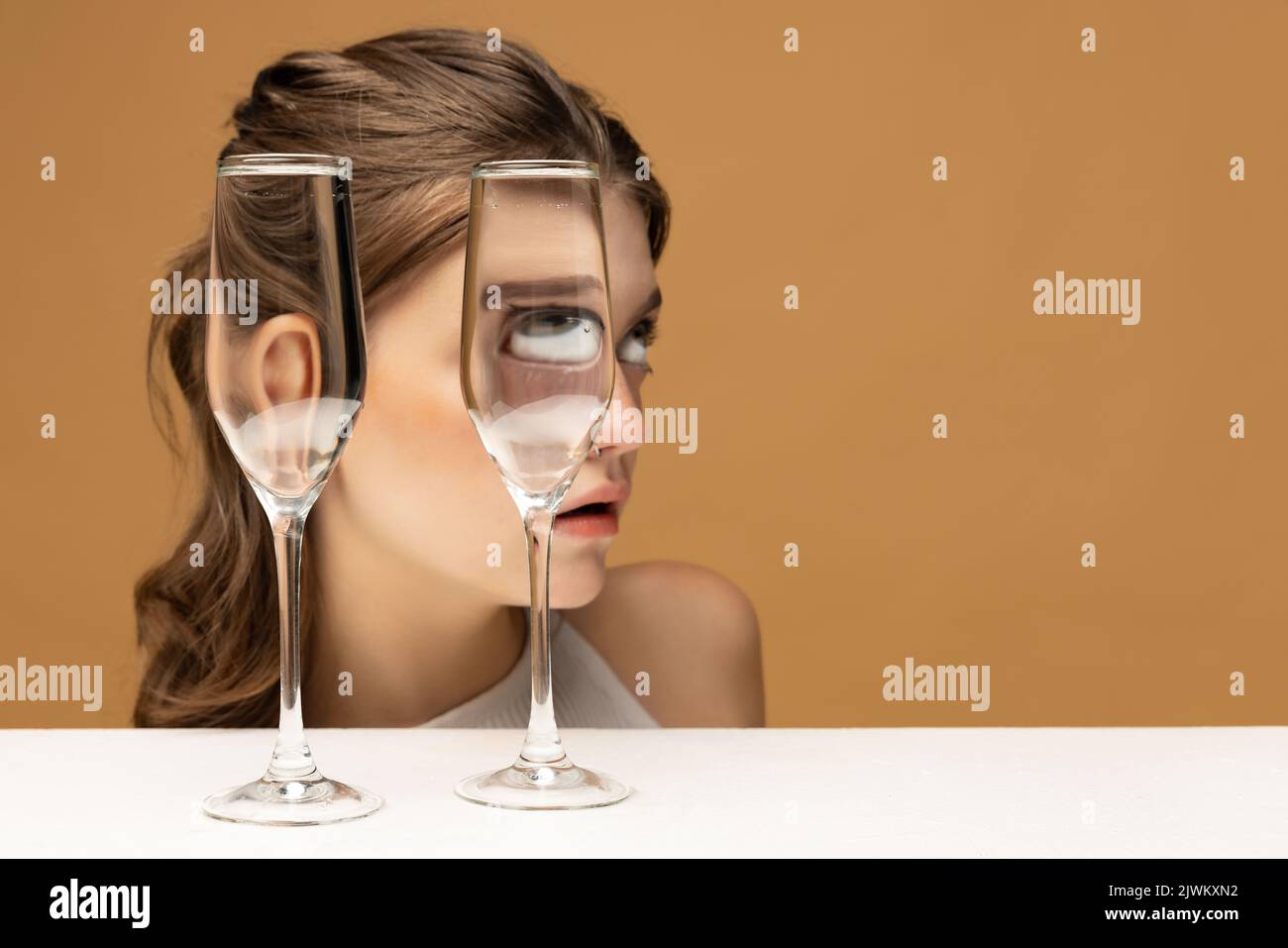 Creative art photography. Stylish girl's face through wine glasses over ...