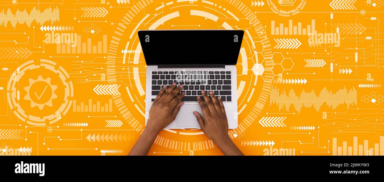 Young black man typing on laptop keyboard with blank screen on orange ...