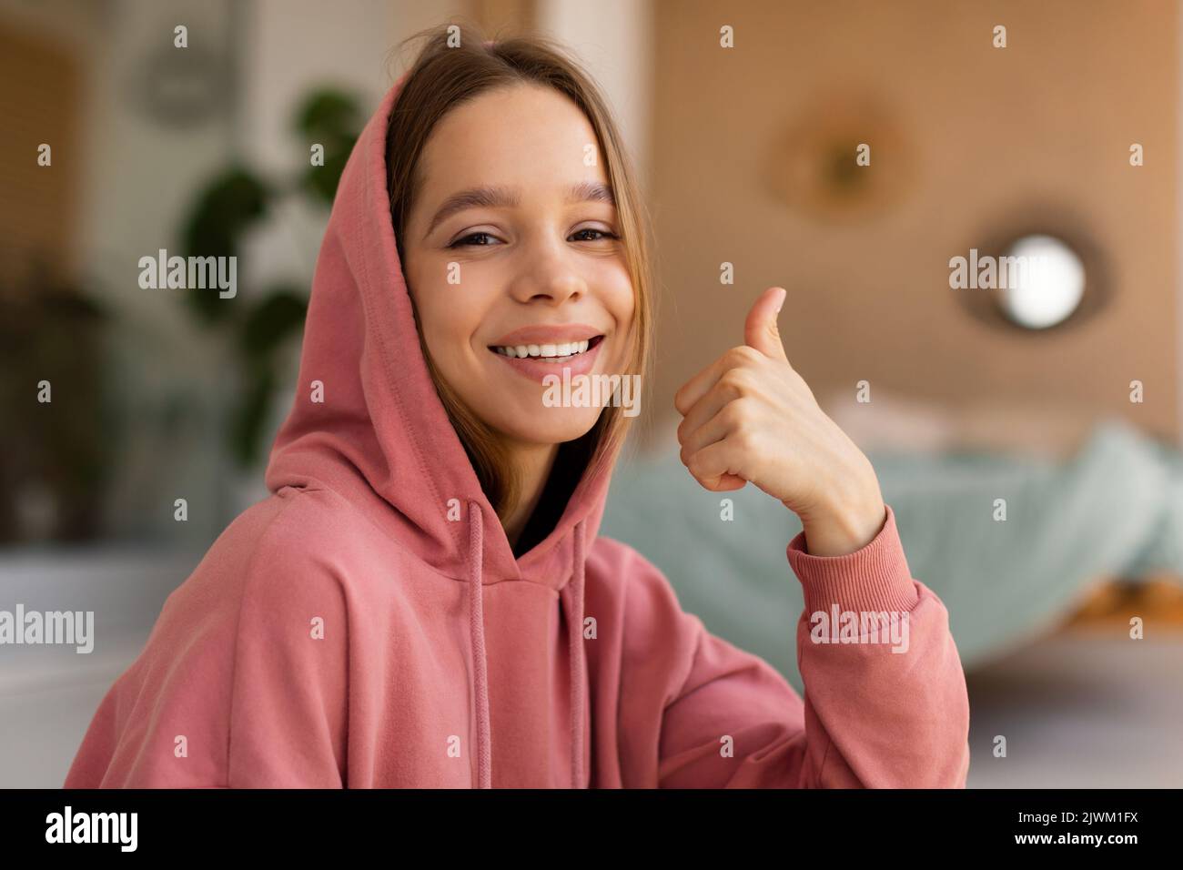 Best choice. Portrait of teen girl showing thumb up gesture, approving ...
