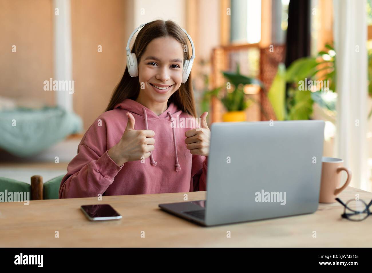 Like homeschooling. Portrait of positive teen girl studying with laptop ...