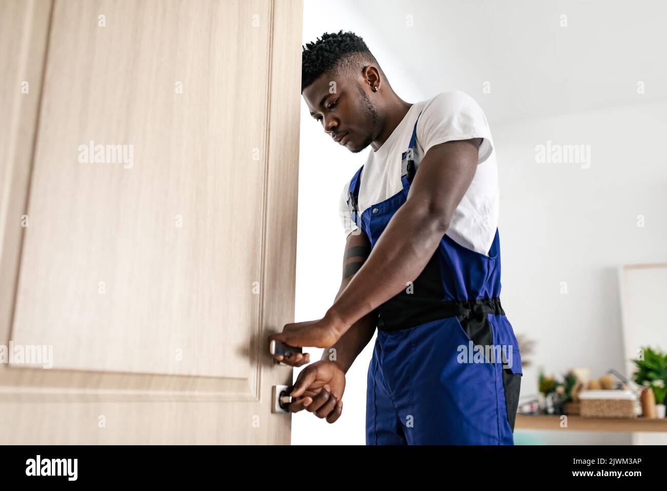 Black Handyman Wearing Coverall Uniform Fixing Door Installing Lock ...