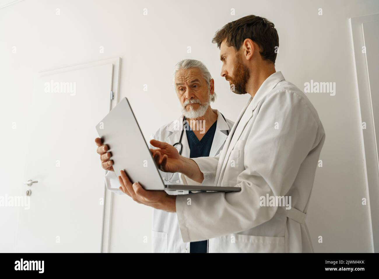 Two doctors are looking at something on the laptop in the doctor's ...