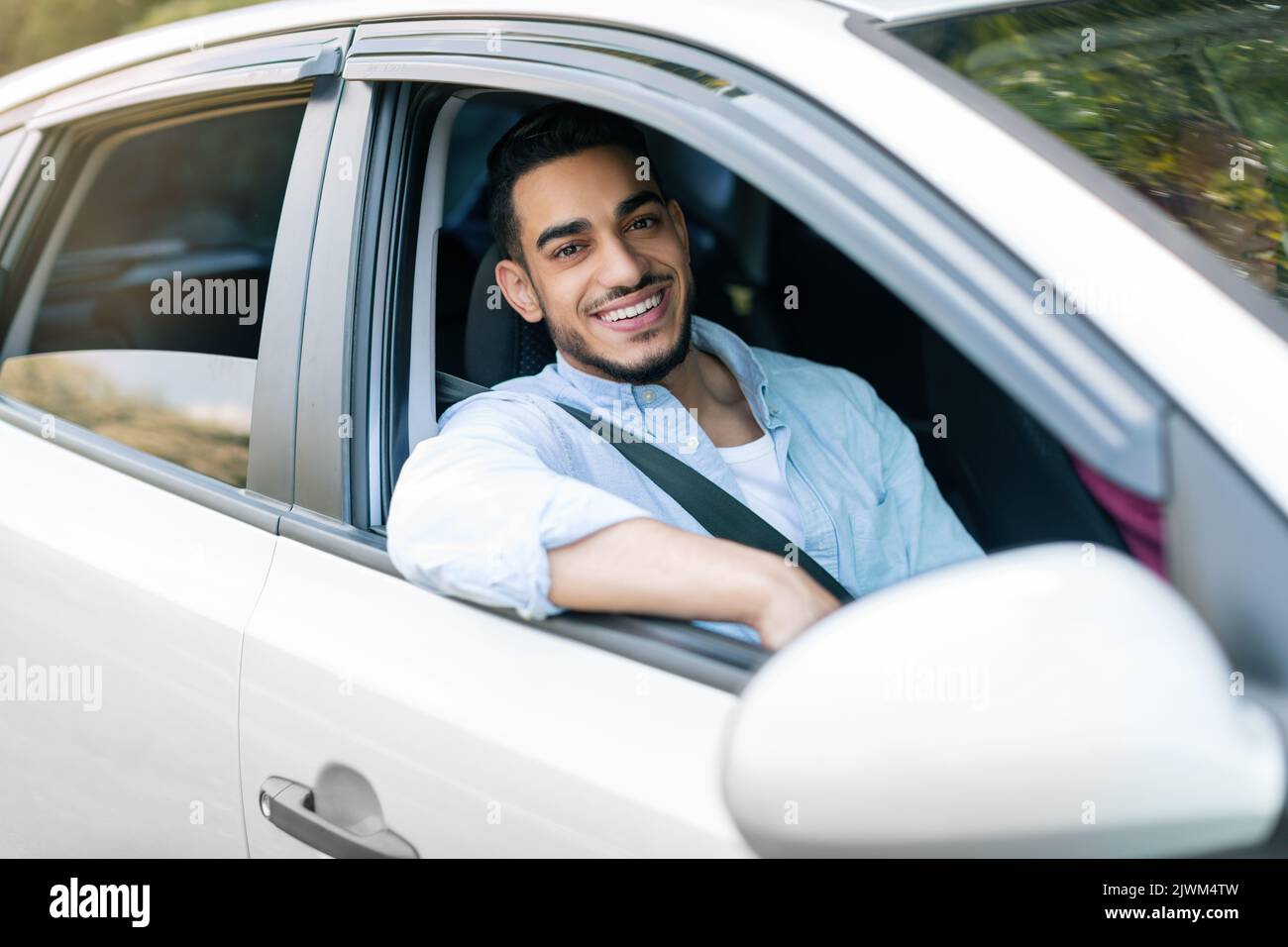 Smiling cheerful millennial arab man fastened with belt enjoy travel on ...