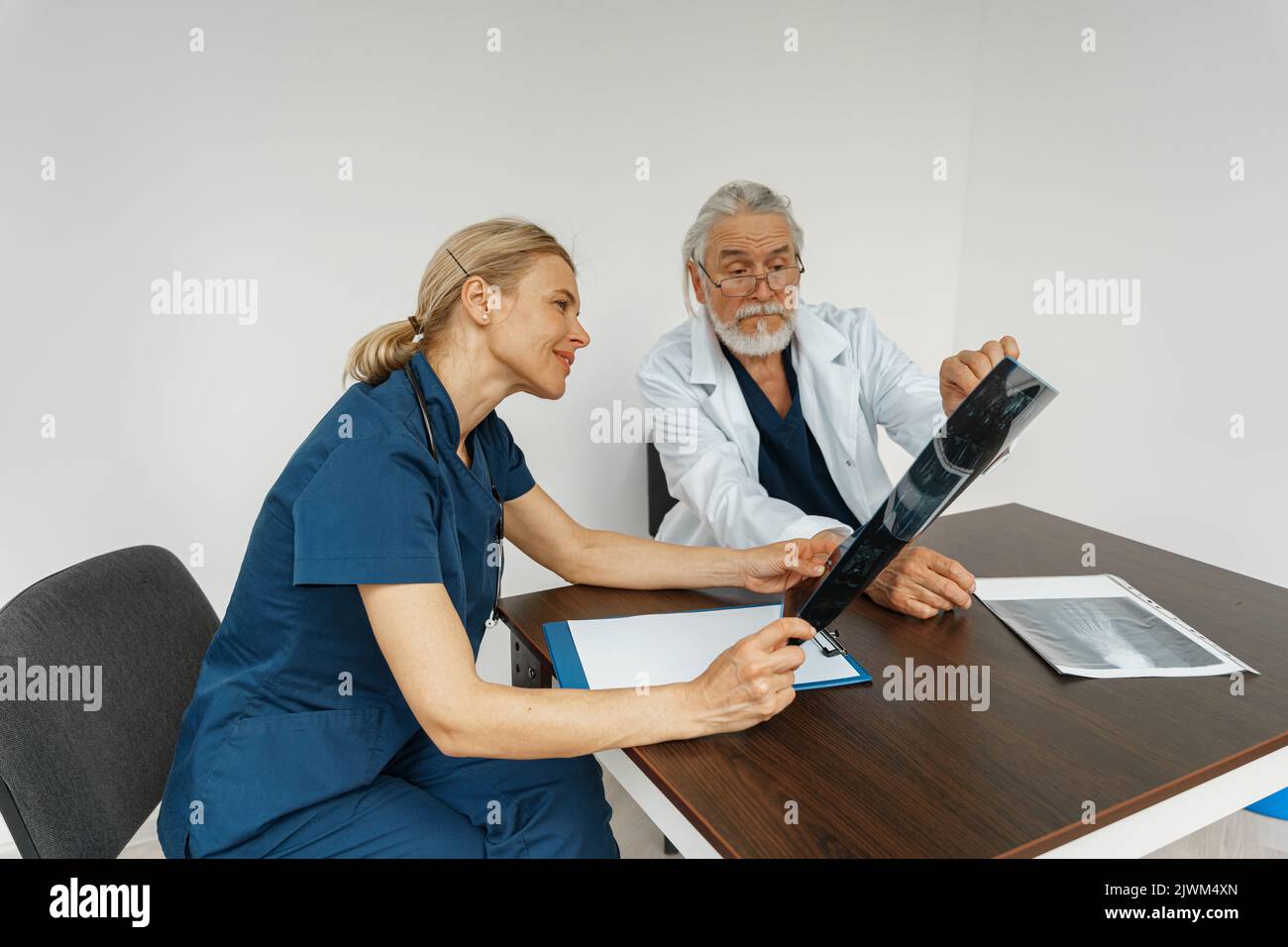 Team of doctors discuss results of X-Ray or MRI scan of patient's spine ...
