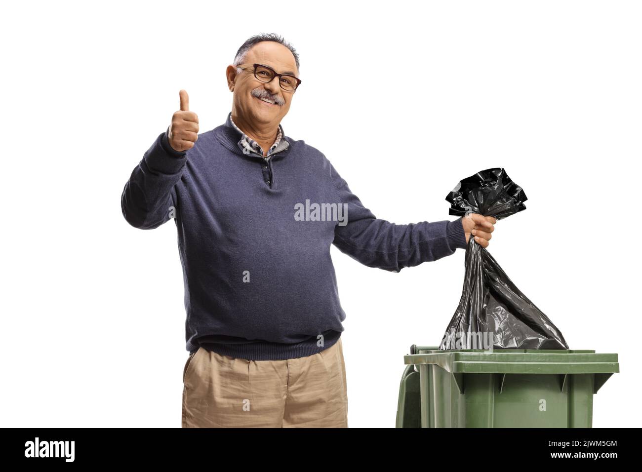 Mature man throwing a plastic bag in a bin and gesturing a thumb up ...