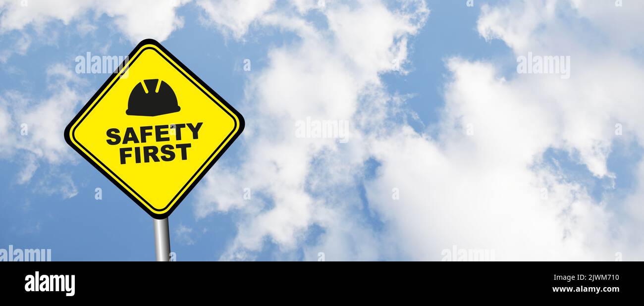 Yellow safety first sign on blue sky background Stock Photo - Alamy