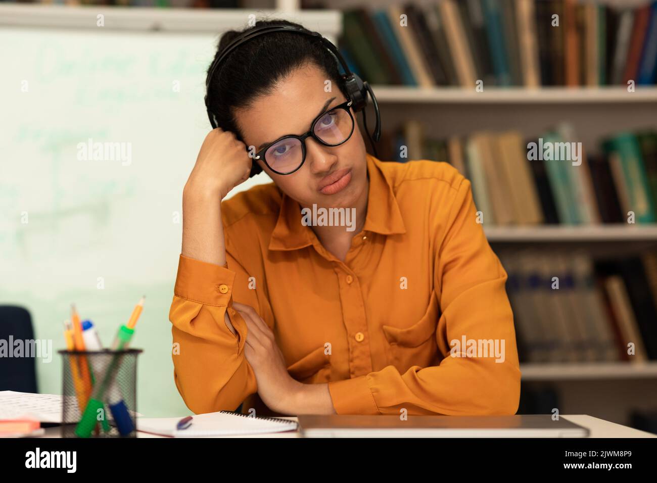 Portrait of exhausted mixed race female teacher feeling tired after ...