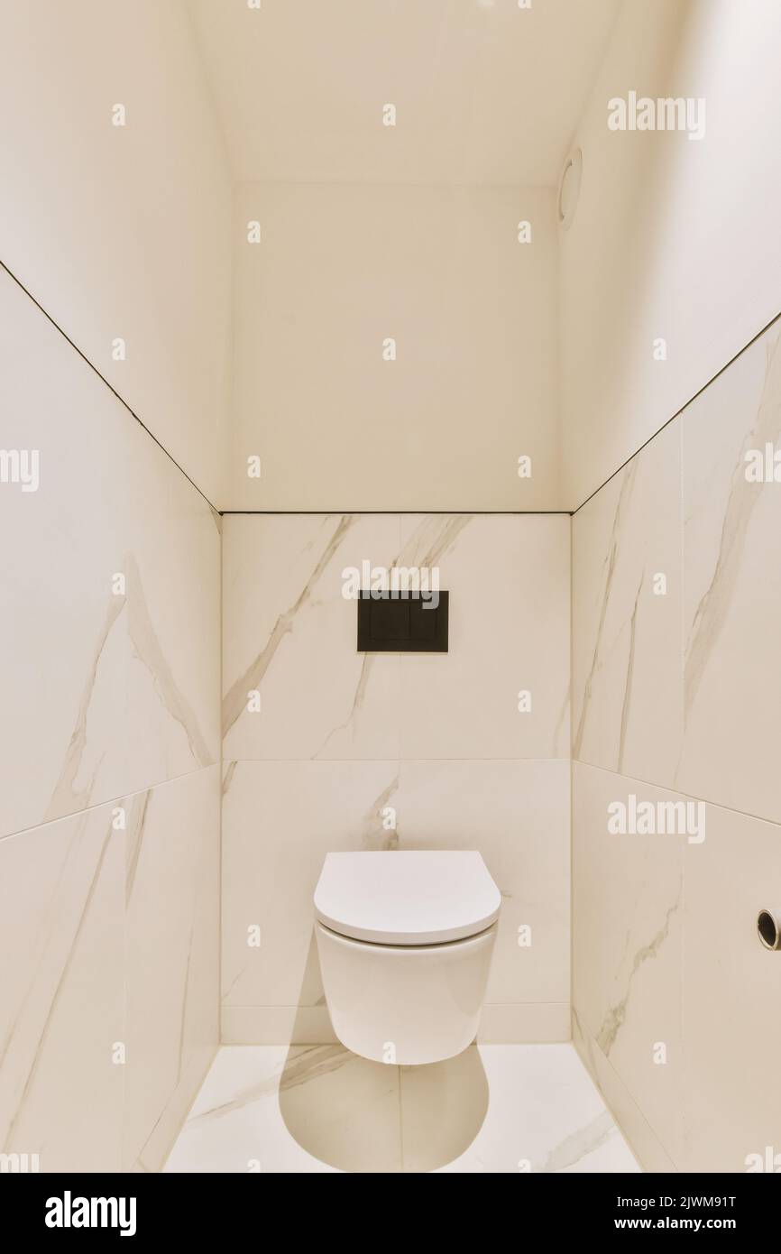 Interior of narrow restroom with wall hung toilet with white walls and ...