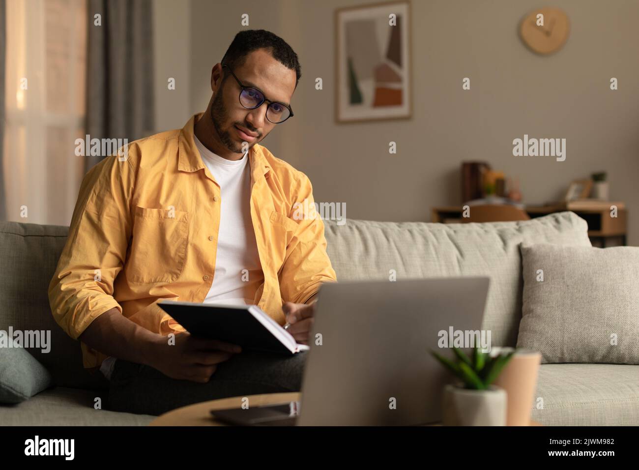 Young black man using laptop pc, working or studying online, taking ...