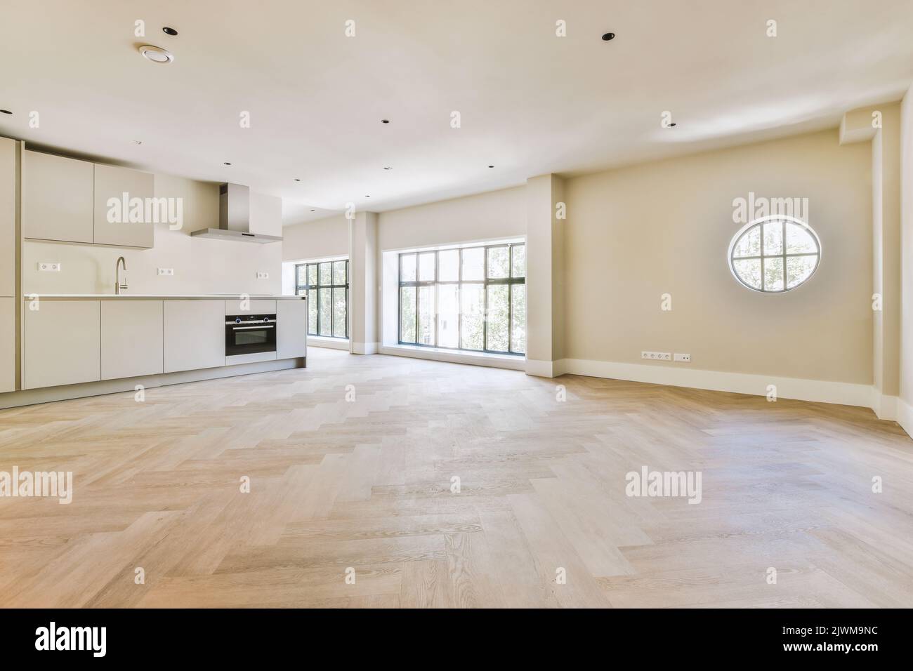 Interior of empty white kitchen with windows and wooden parquet floor ...