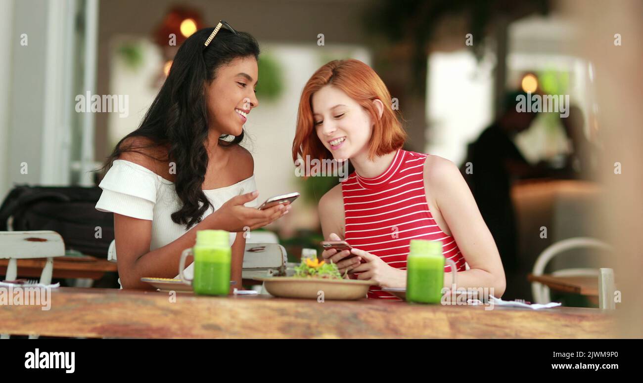 Friend showing cellphone screen to girl, candid and casual of two ...