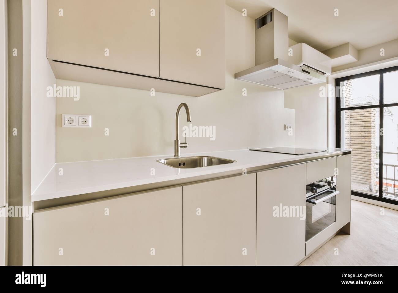 Interior of empty white kitchen with windows and wooden parquet floor ...