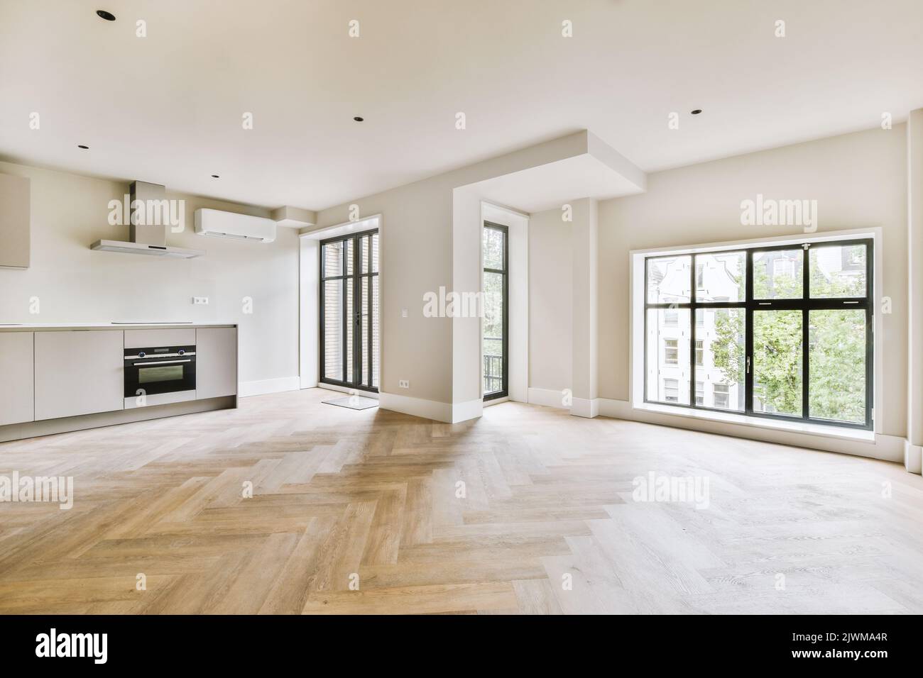 Interior of empty white kitchen with windows and wooden parquet floor ...