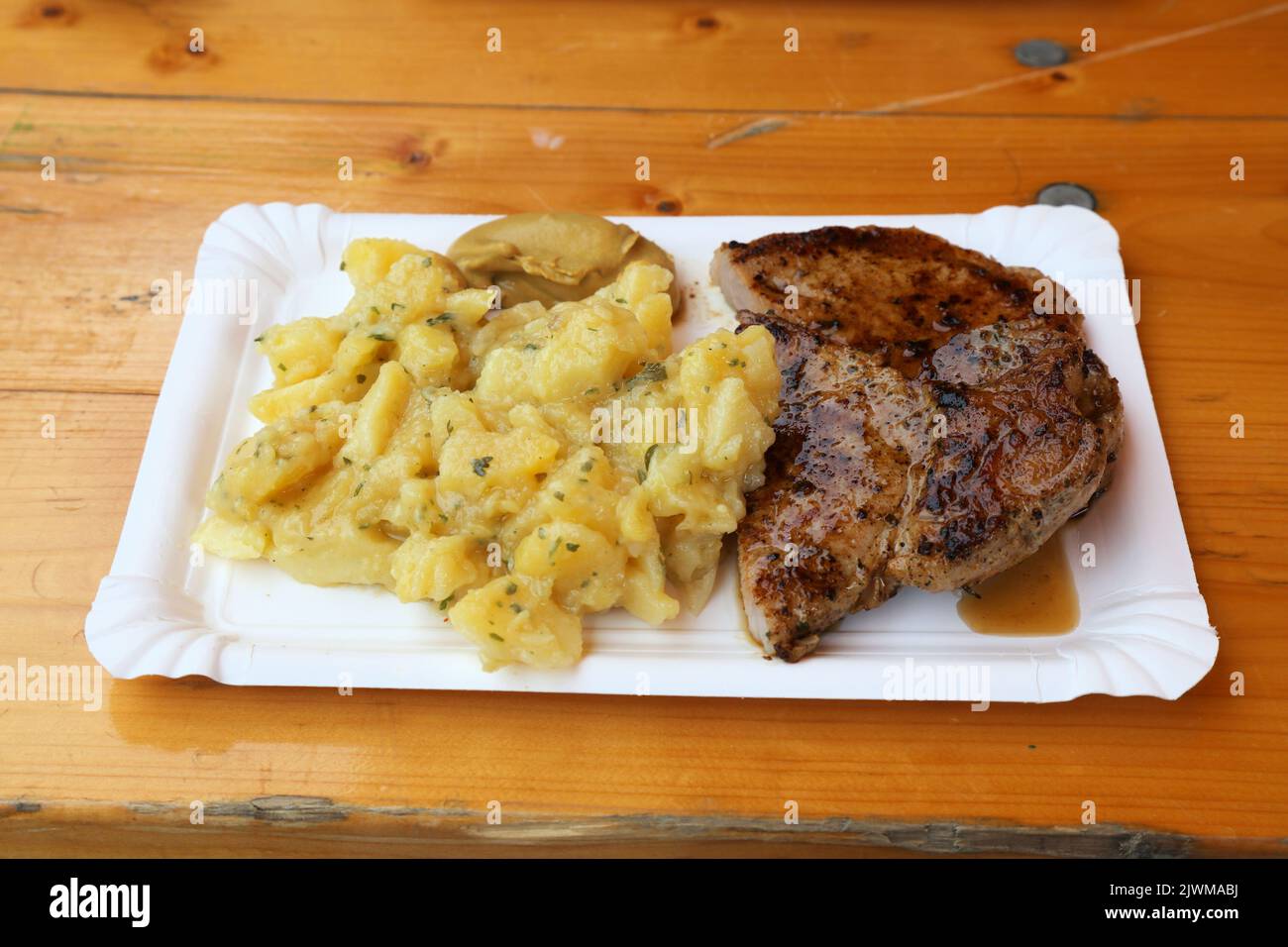 Austria festival food. Potato salad (Kartoffelsalat) and grilled pork ...