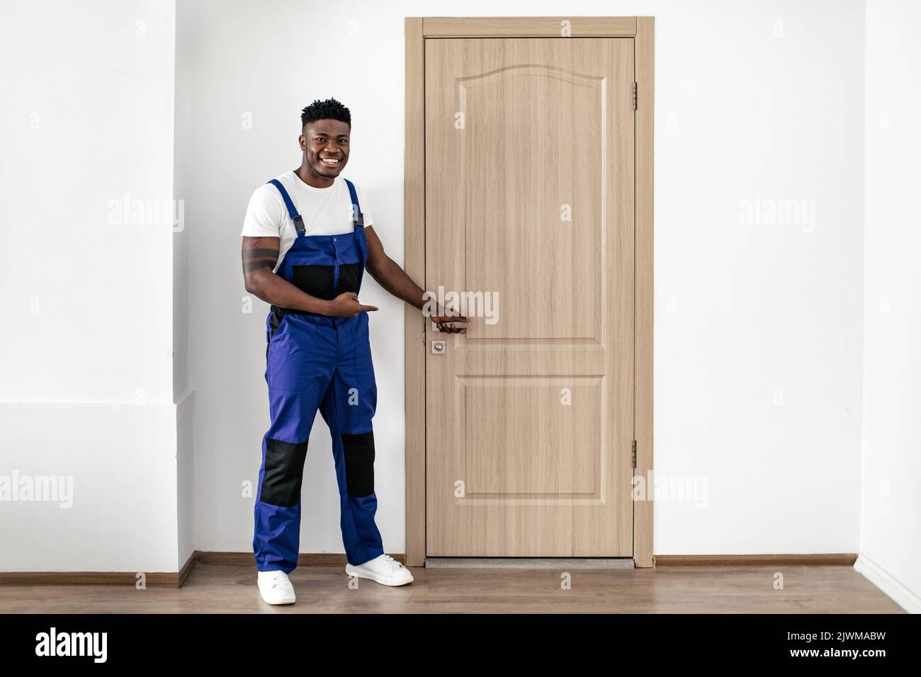Black Male Worker Pointing Finger At New Entry Door Indoors Stock Photo ...