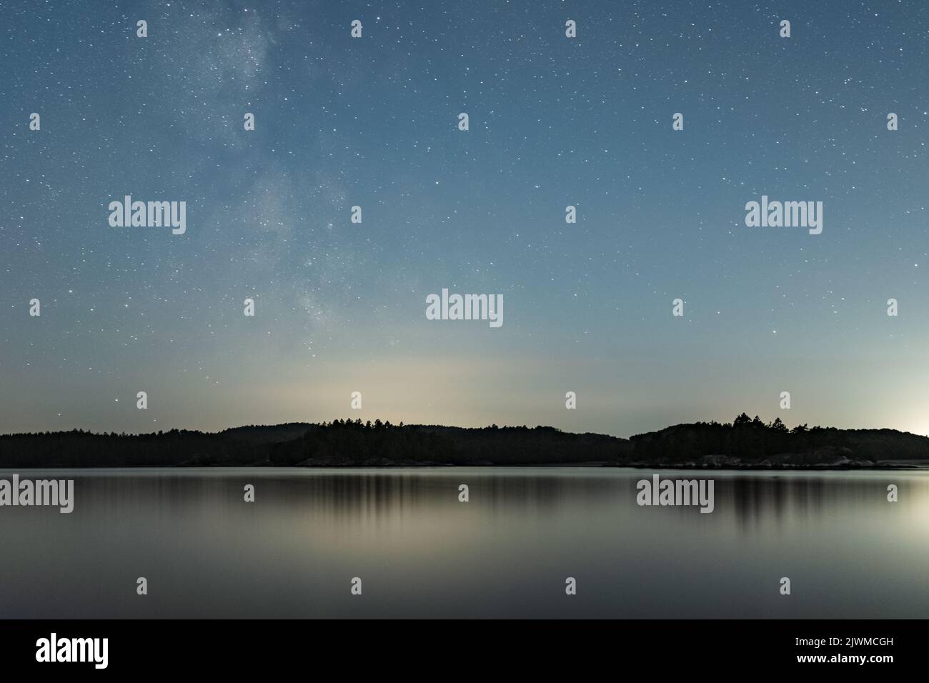 Magnificent night scenery. Calm sea, shore and starry sky with milky ...