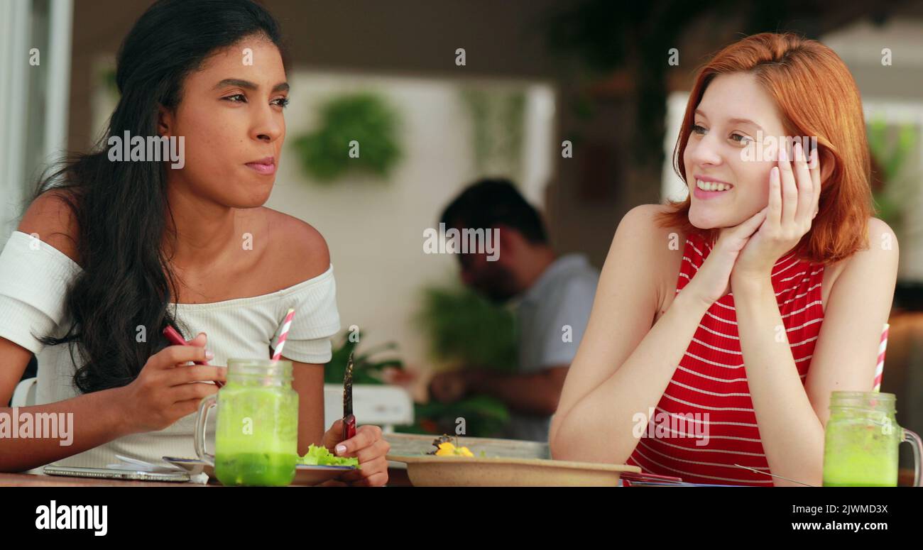 Diverse female friends together eating meal Stock Photo - Alamy