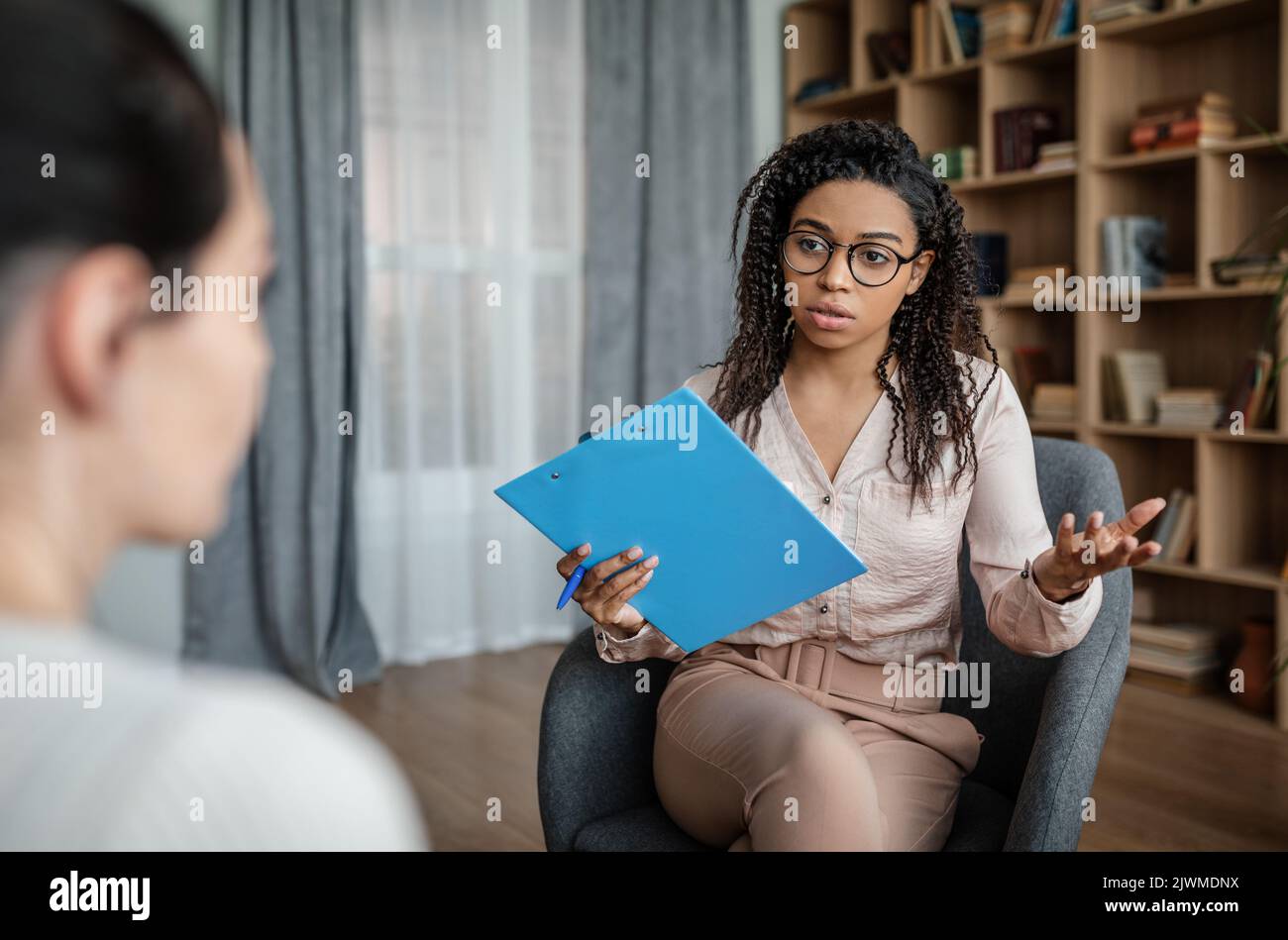 Serious african american young woman psychologist advises european lady ...