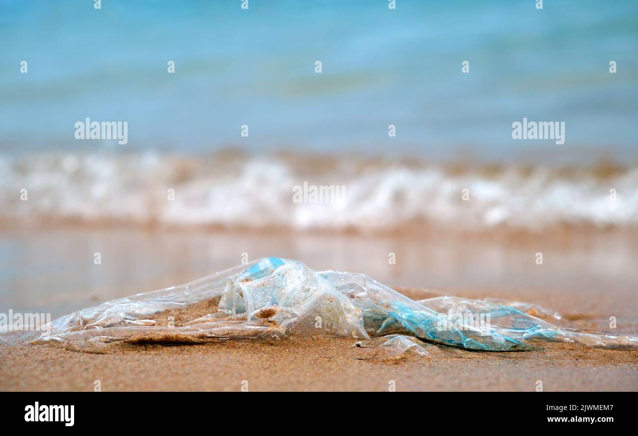 Left behind plastic bag garbage on sandy beach. Empty used dirty litter ...