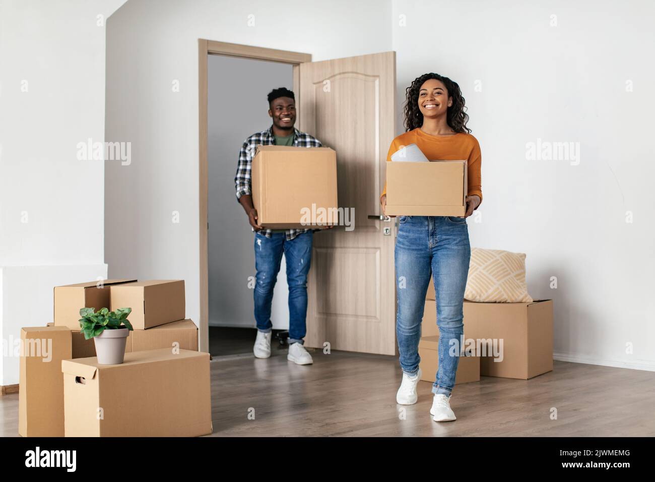 Cheerful Black Couple Entering New House Carrying Moving Boxes Indoor ...