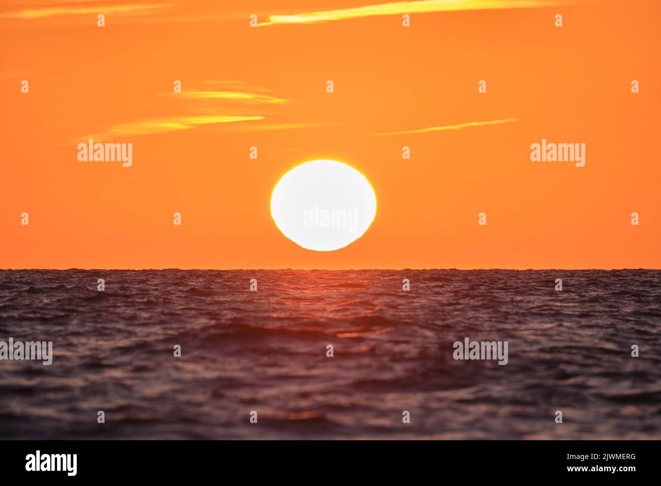 Ocean sunset. Big white sun on dramatic bright sky background, soft ...