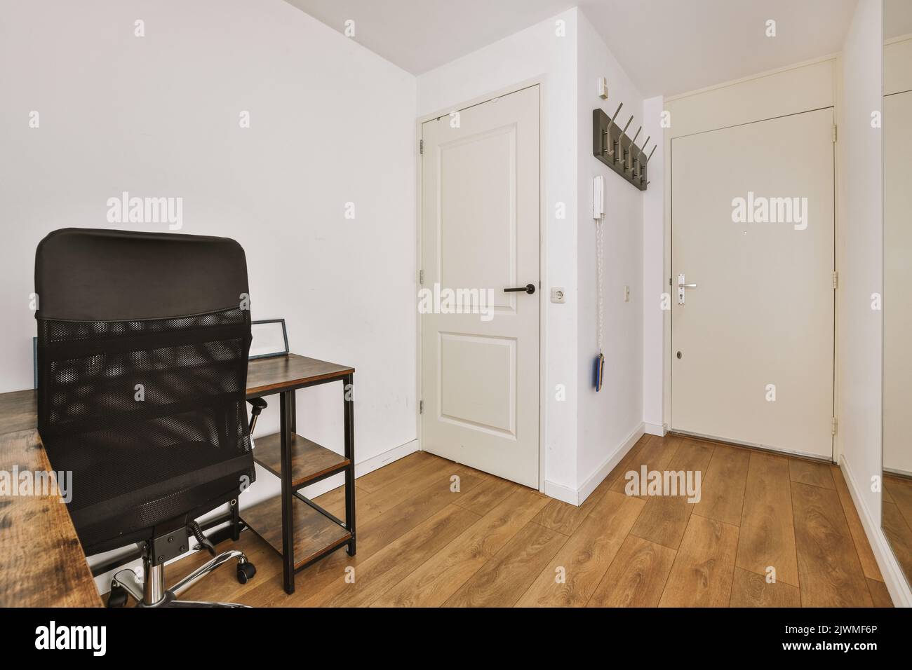 Comfortable chair placed near desk with computer monitors and ...