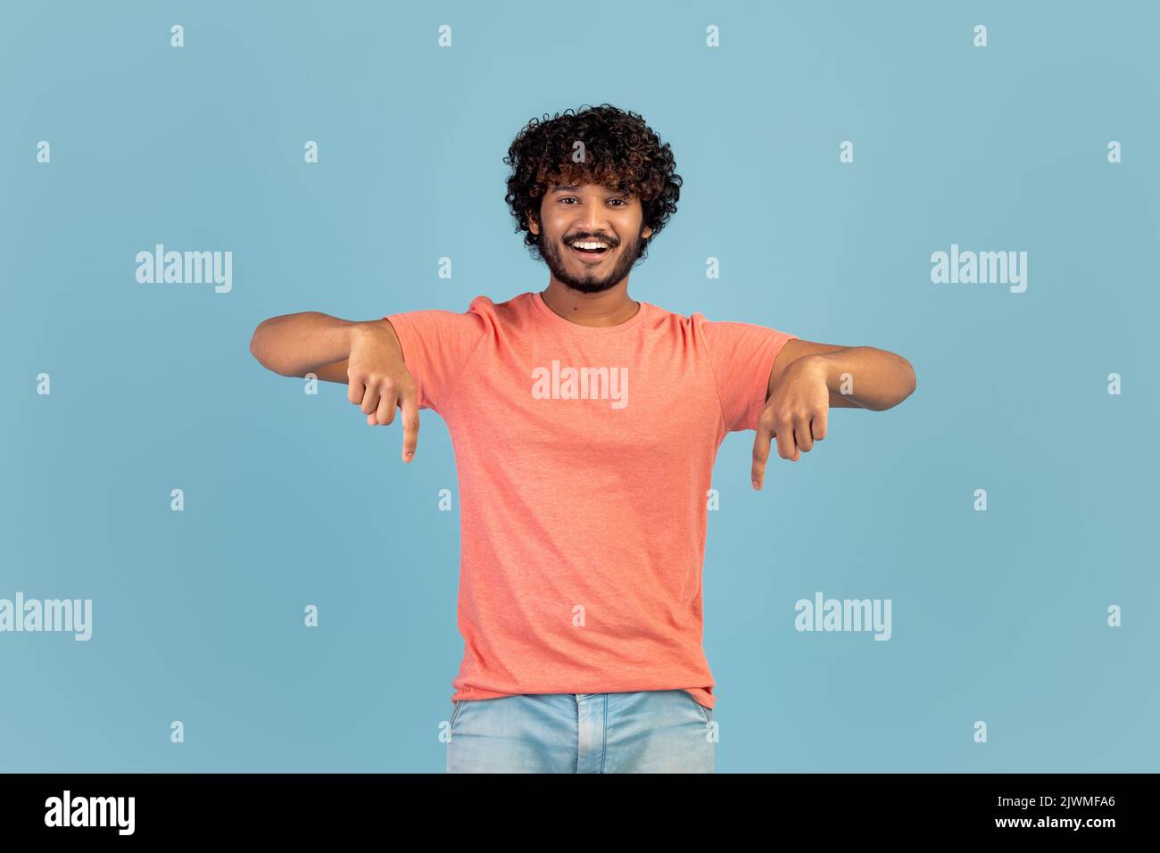 Happy indian man pointing down and smiling Stock Photo - Alamy