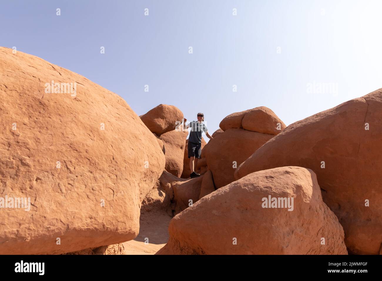 Young woman climbing through rocks at Goblin Valley State Park in Utah ...