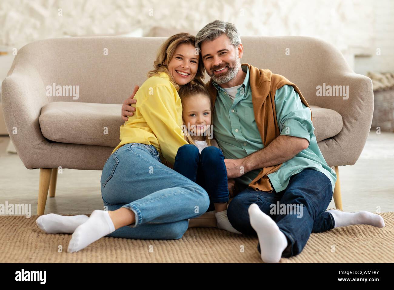 Happy Parents And Kid Daughter Hugging Posing At Home Stock Photo - Alamy