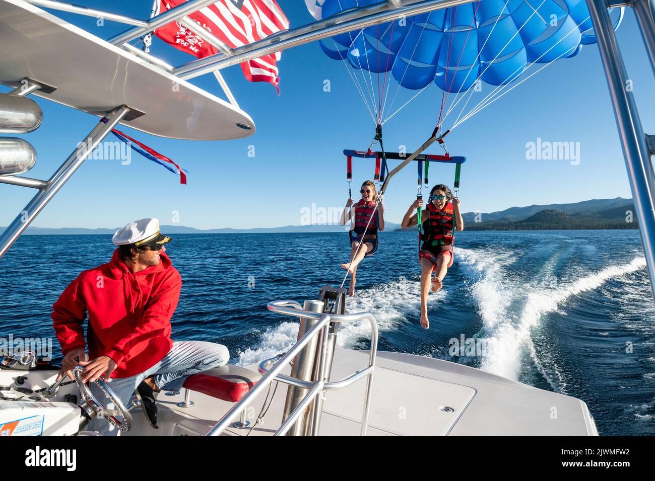 The captain smiles as he sends off two women parasailing Stock Photo ...